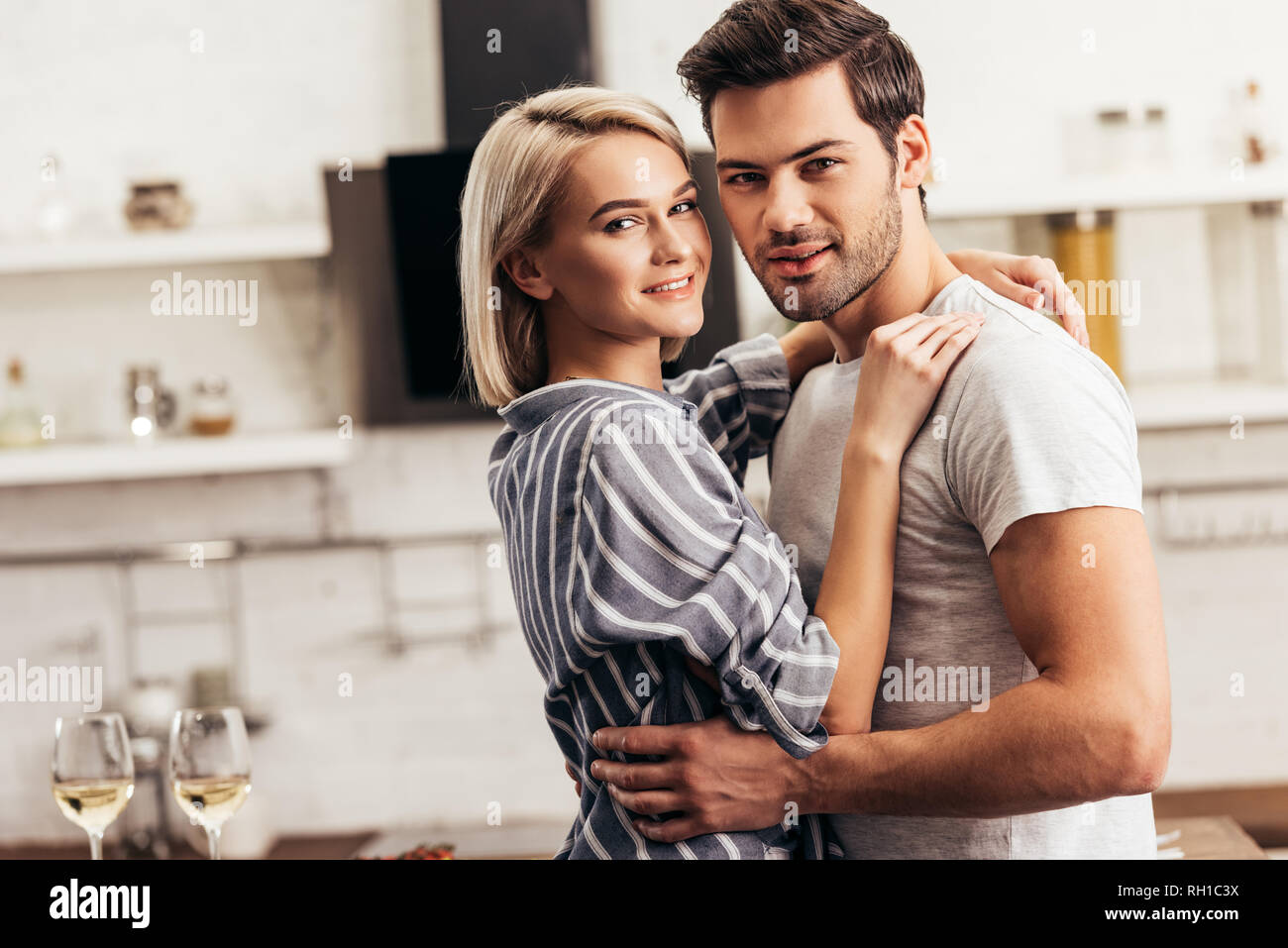 selective focus of handsome boyfriend and attractive girlfriend hugging ...