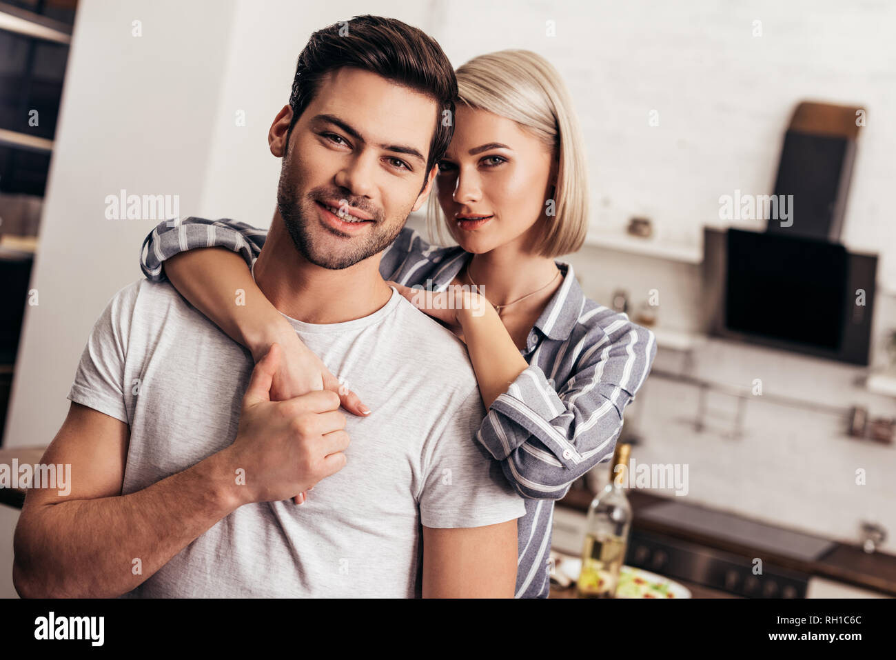 selective focus of handsome boyfriend and attractive girlfriend hugging ...