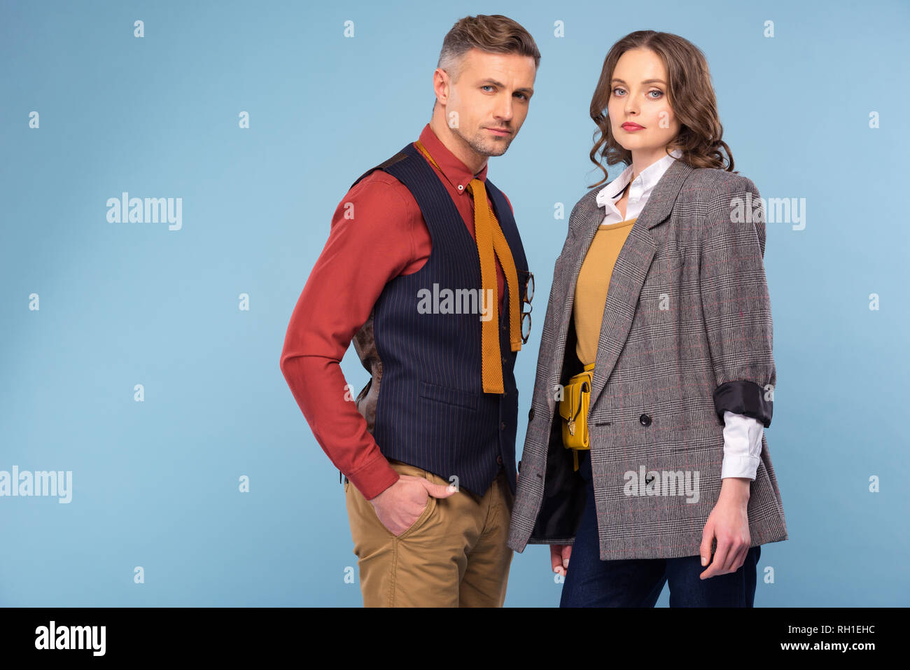 beautiful fashionable couple in formal wear looking at camera and ...