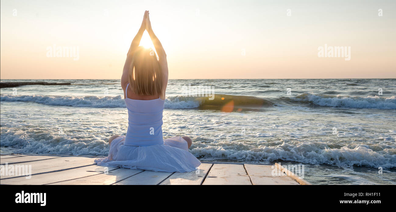 Woman meditating at the sea Stock Photo - Alamy