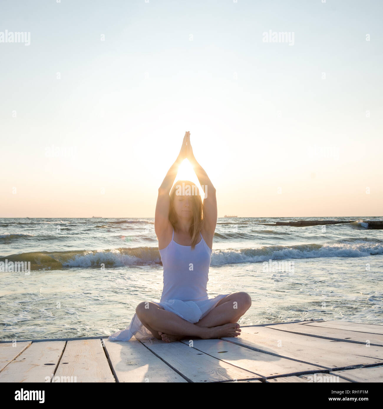 Woman meditating at the sea Stock Photo - Alamy
