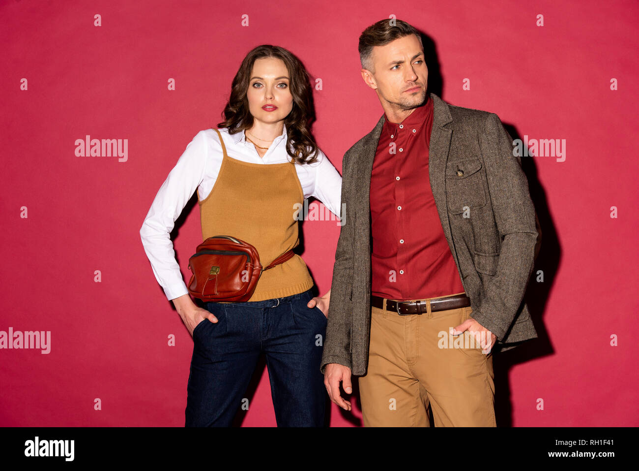 beautiful stylish couple in formal wear posing on red background Stock ...