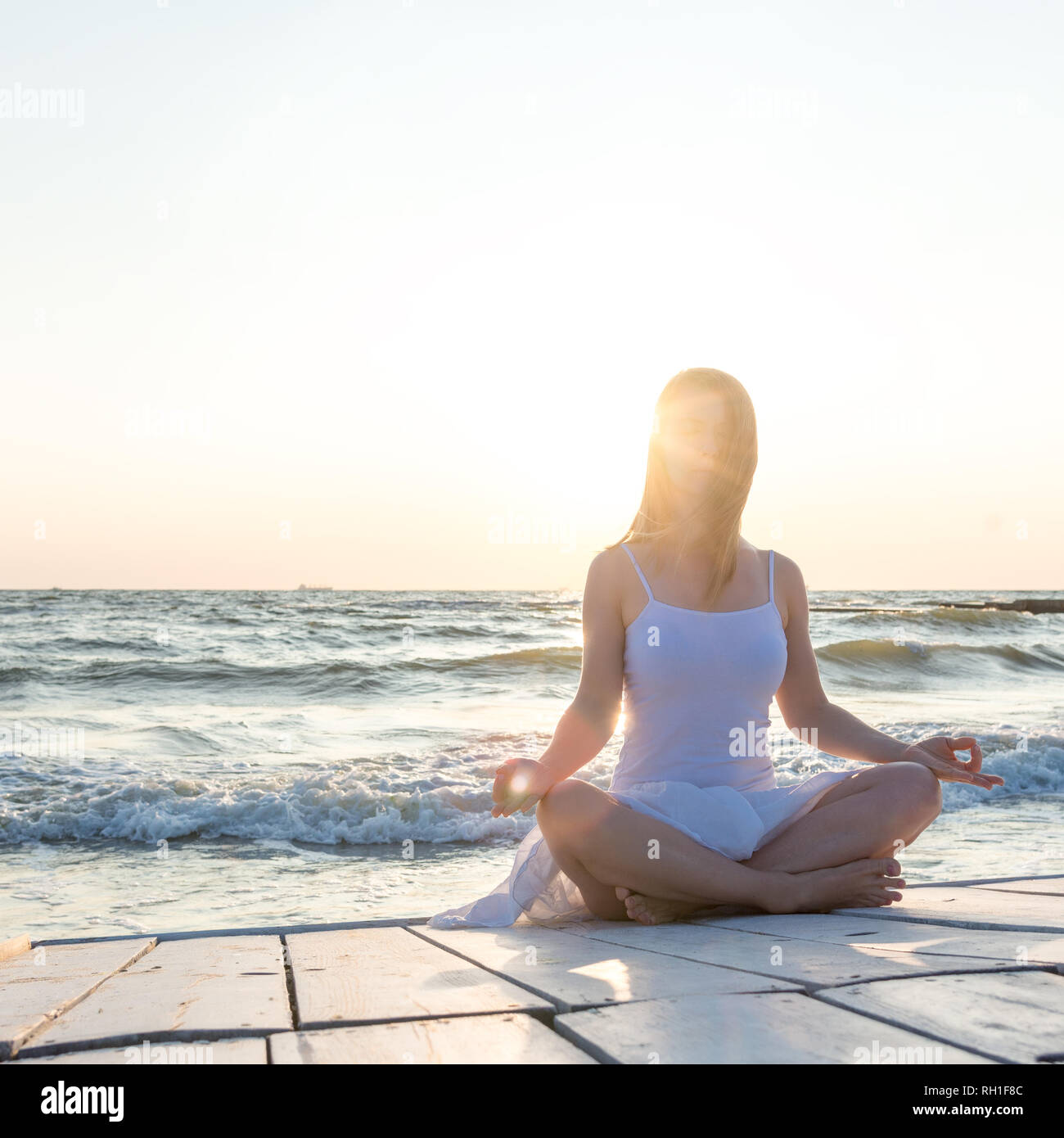 Woman meditating at the sea Stock Photo - Alamy