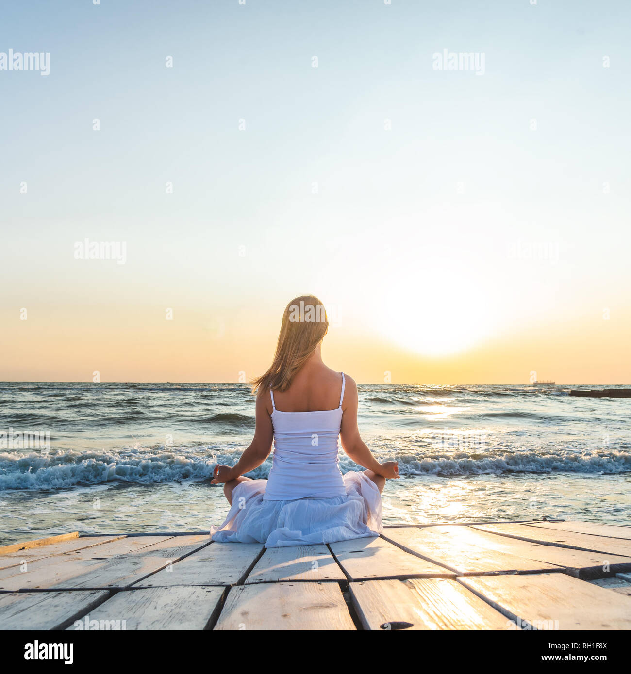 Woman meditating at the sea Stock Photo - Alamy