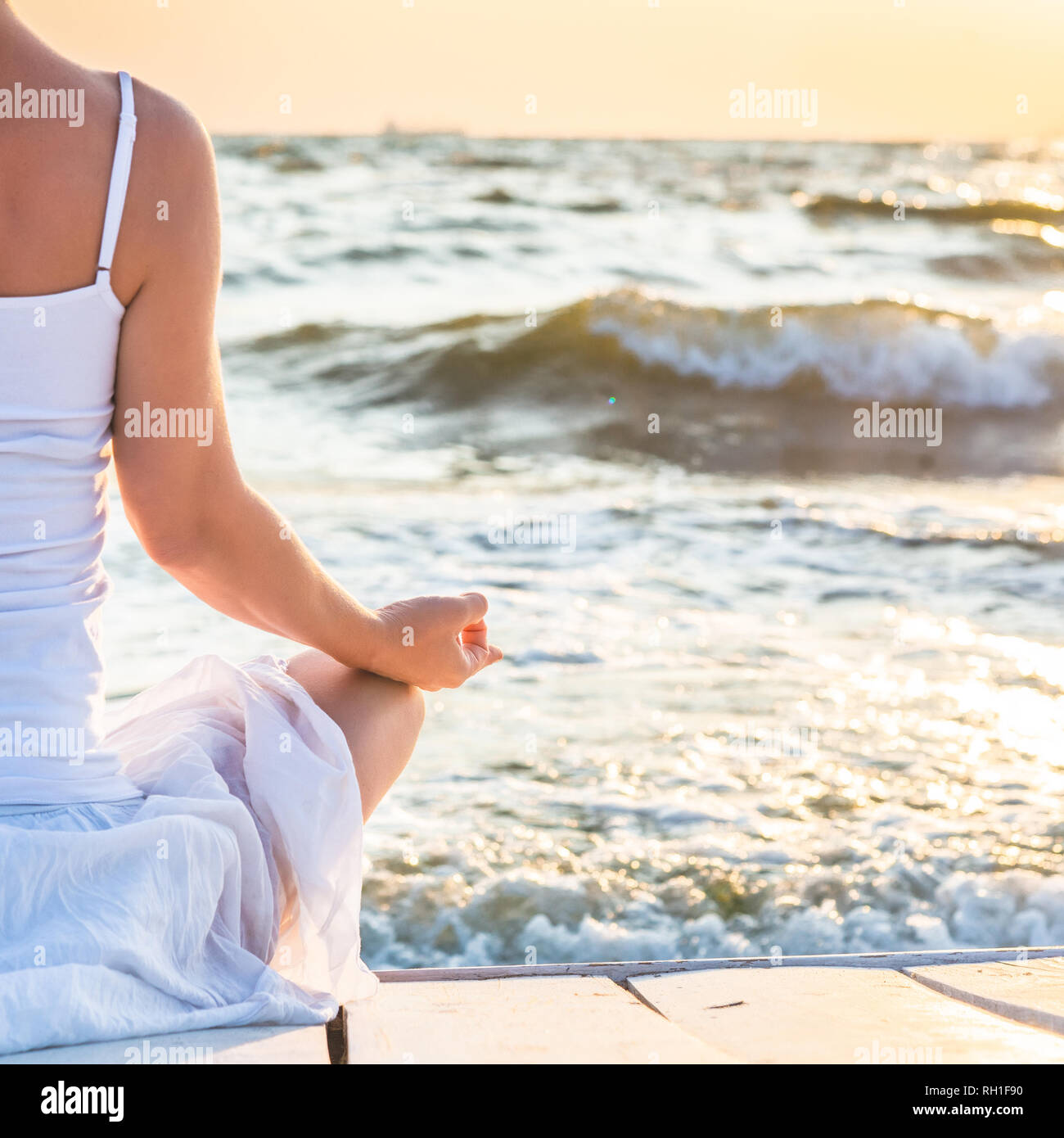 Woman meditating at the sea Stock Photo - Alamy