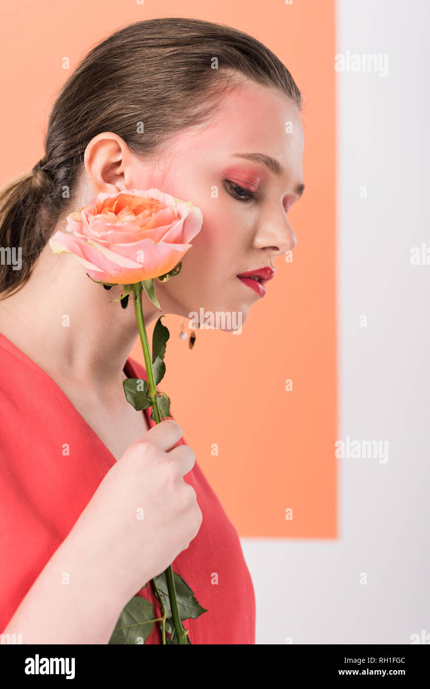 portrait of beautiful stylish girl holding rose and posing isolated on ...