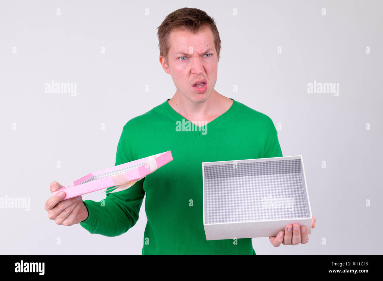 Confused young man looking upset while opening empty gift box Stock ...