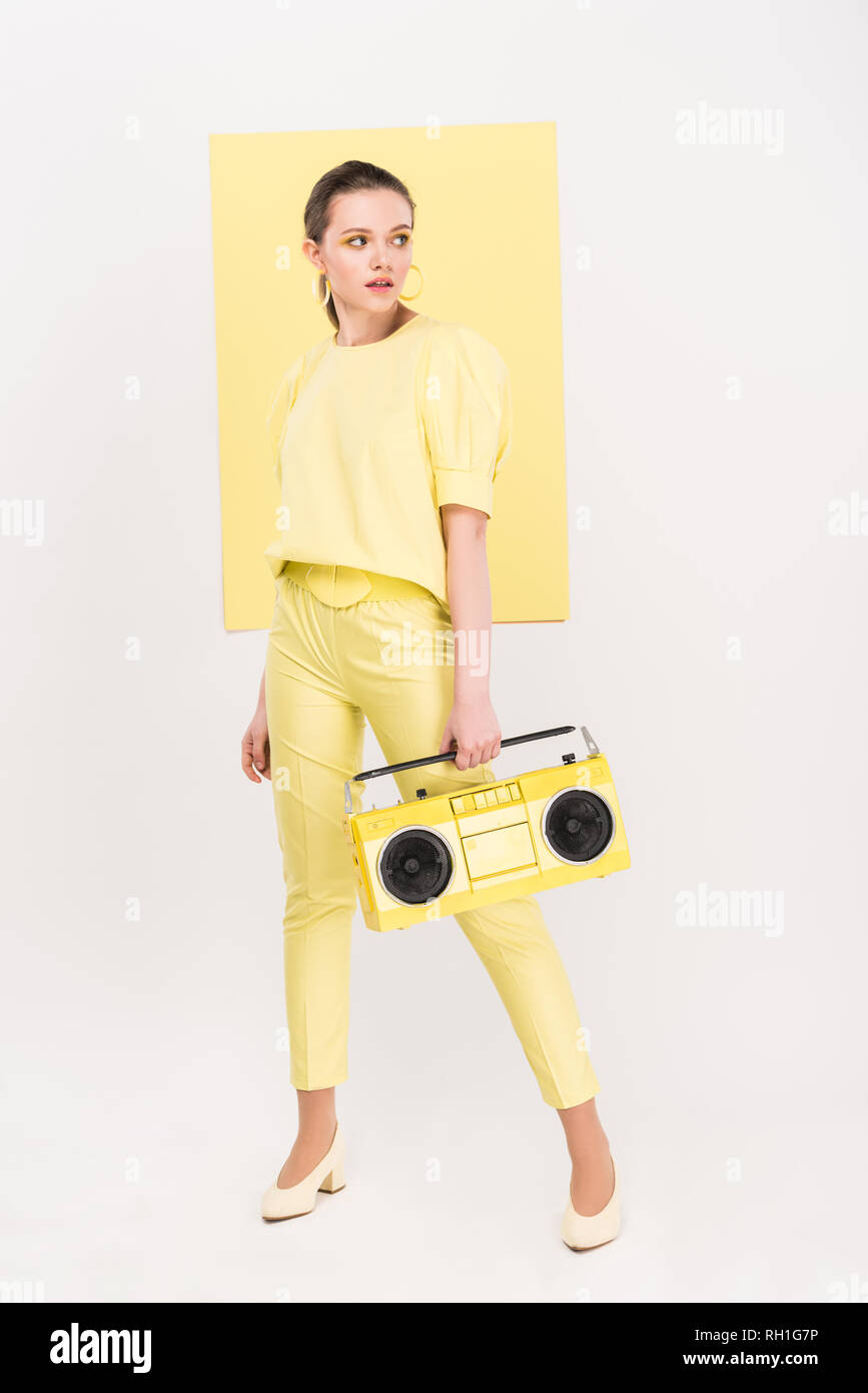 stylish girl holding retro boombox, looking away and posing with ...