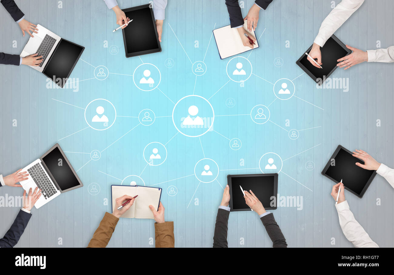 Group of people with devices in hands working in team on tablets ...