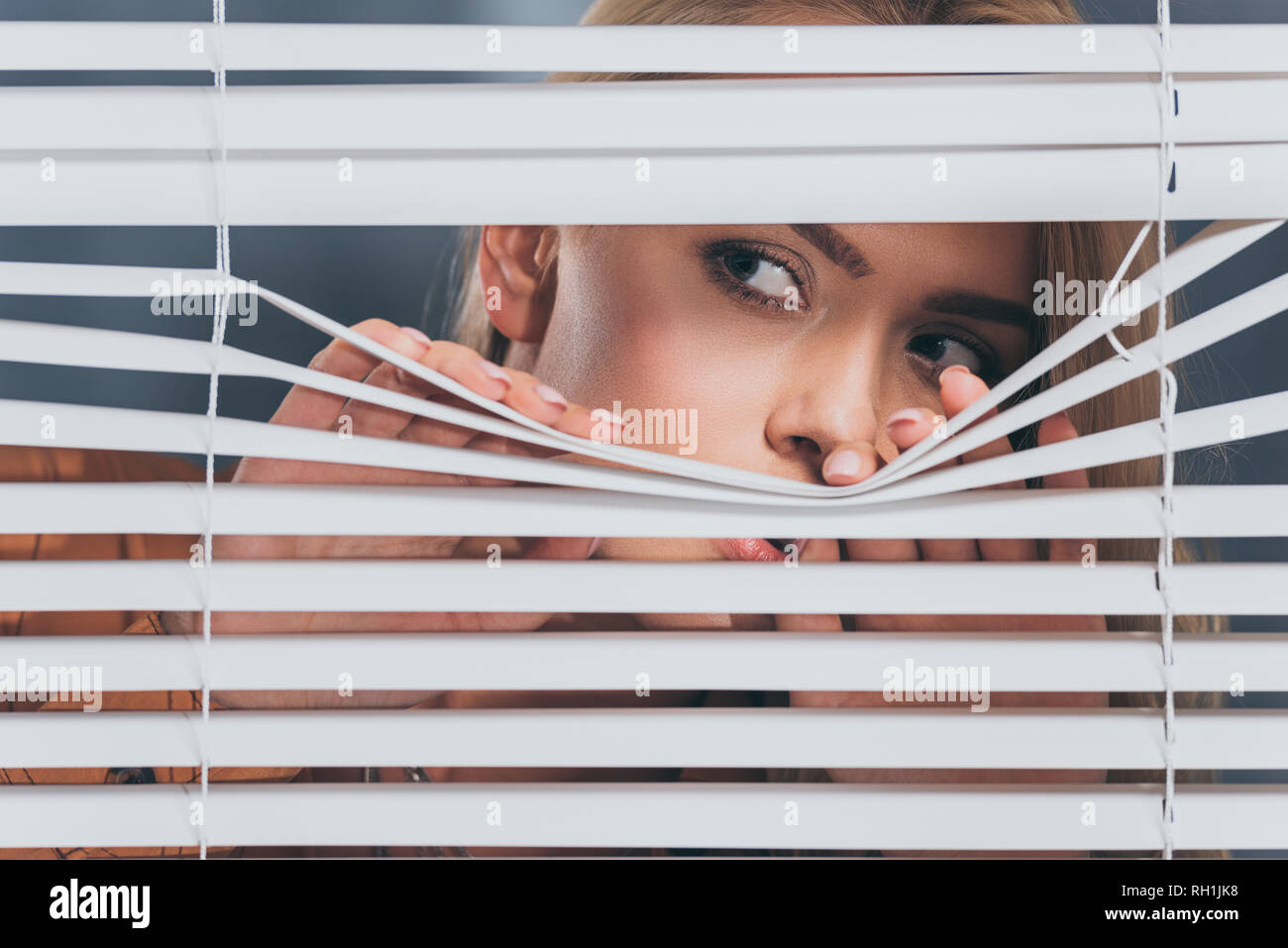 Peeking through blinds hi-res stock photography and images - Alamy