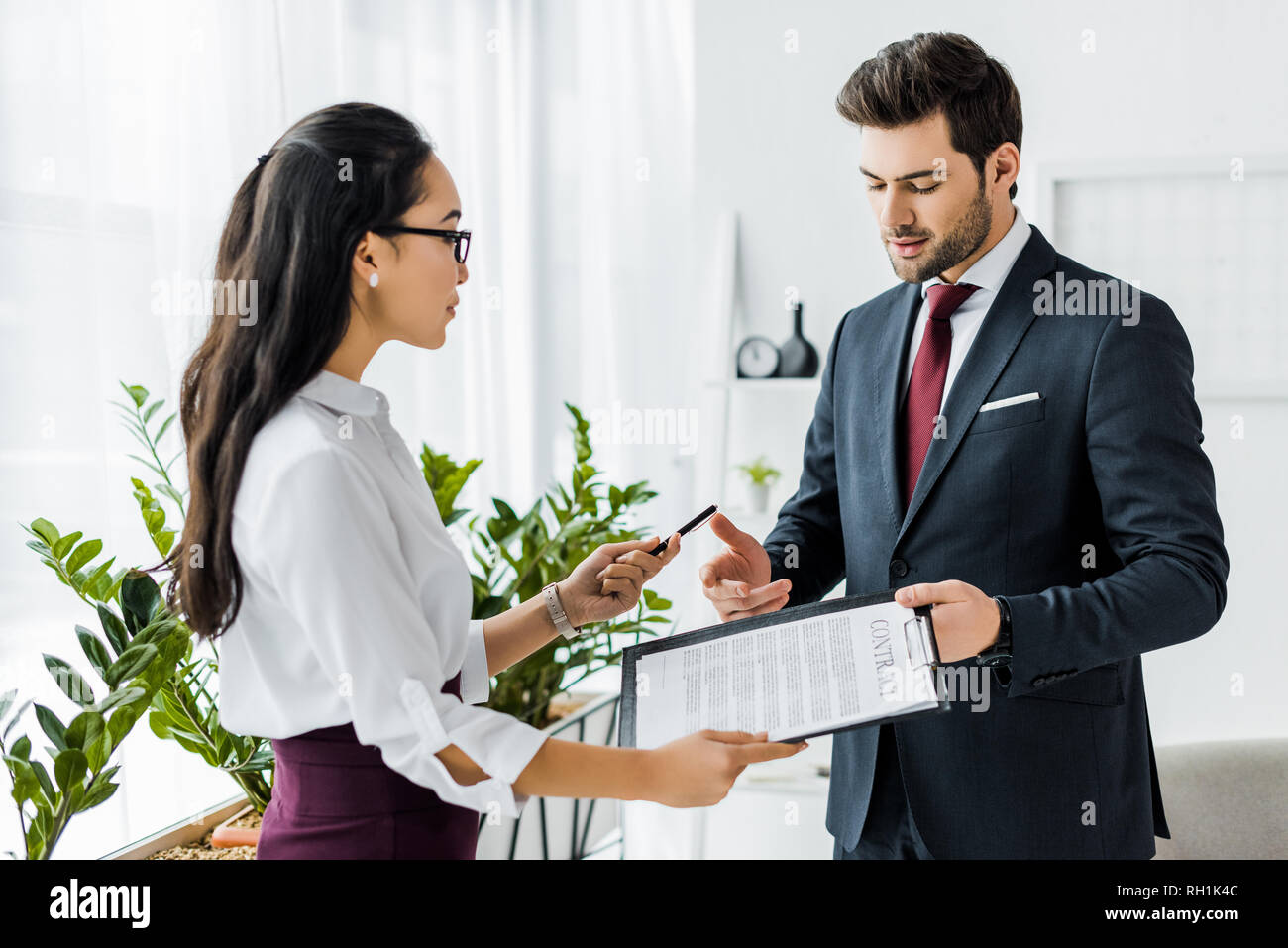businesspeople in formal wear signing contract in office Stock Photo ...
