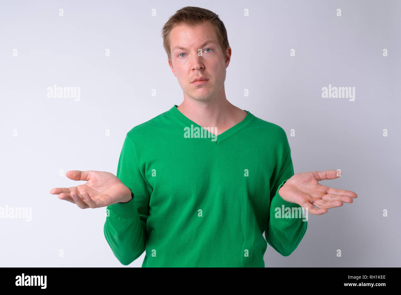 Portrait of confused young man shrugging shoulders Stock Photo - Alamy