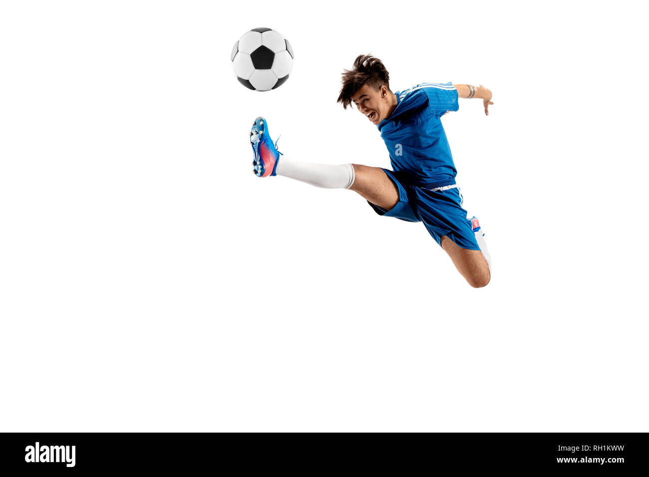 Young boy with soccer ball doing flying kick, isolated on white ...