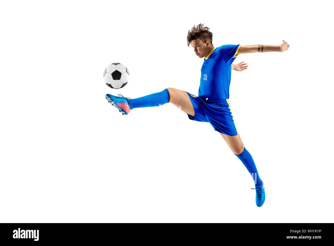 Young boy with soccer ball doing flying kick, isolated on white ...