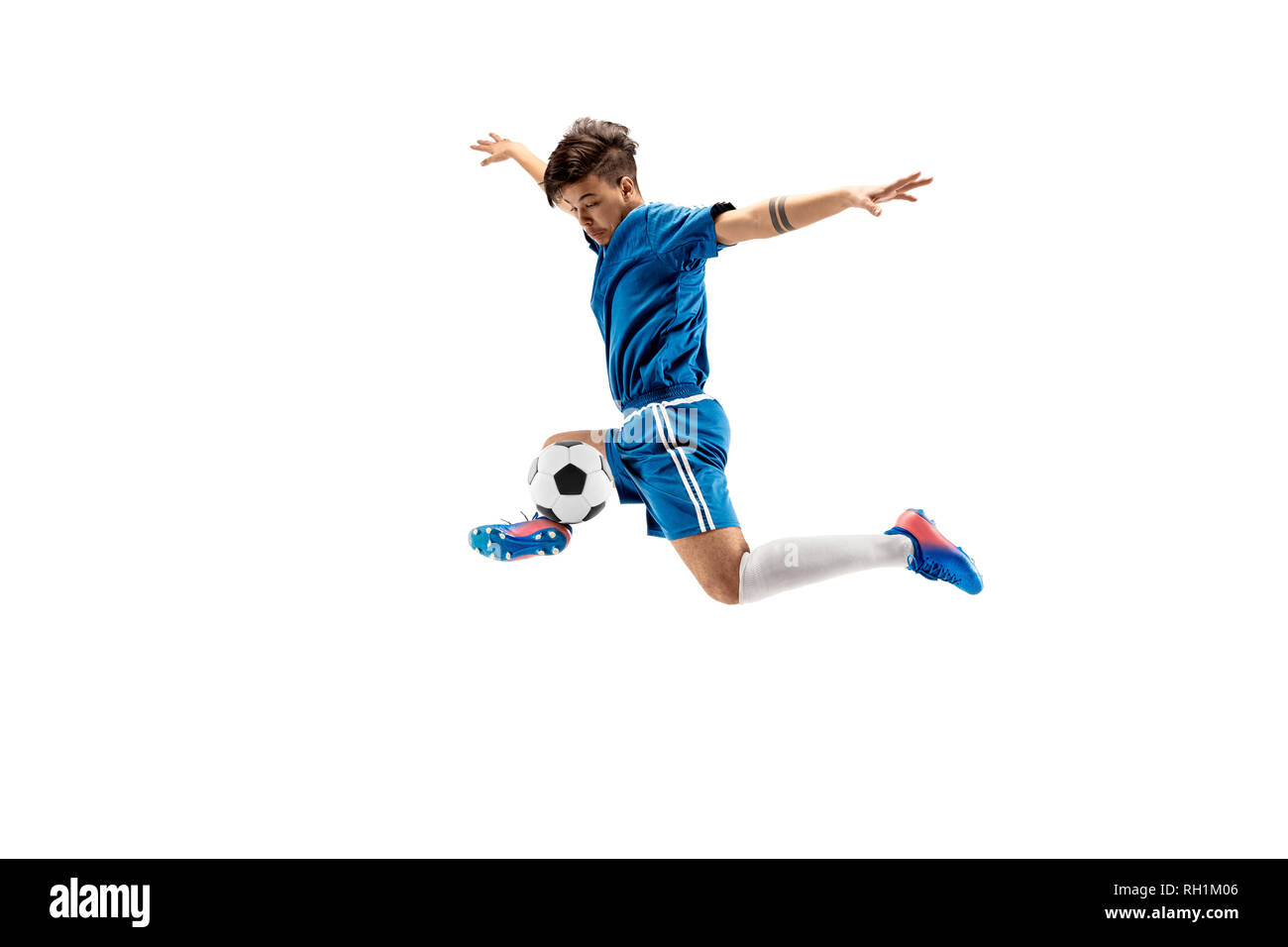 Young boy with soccer ball doing flying kick, isolated on white ...