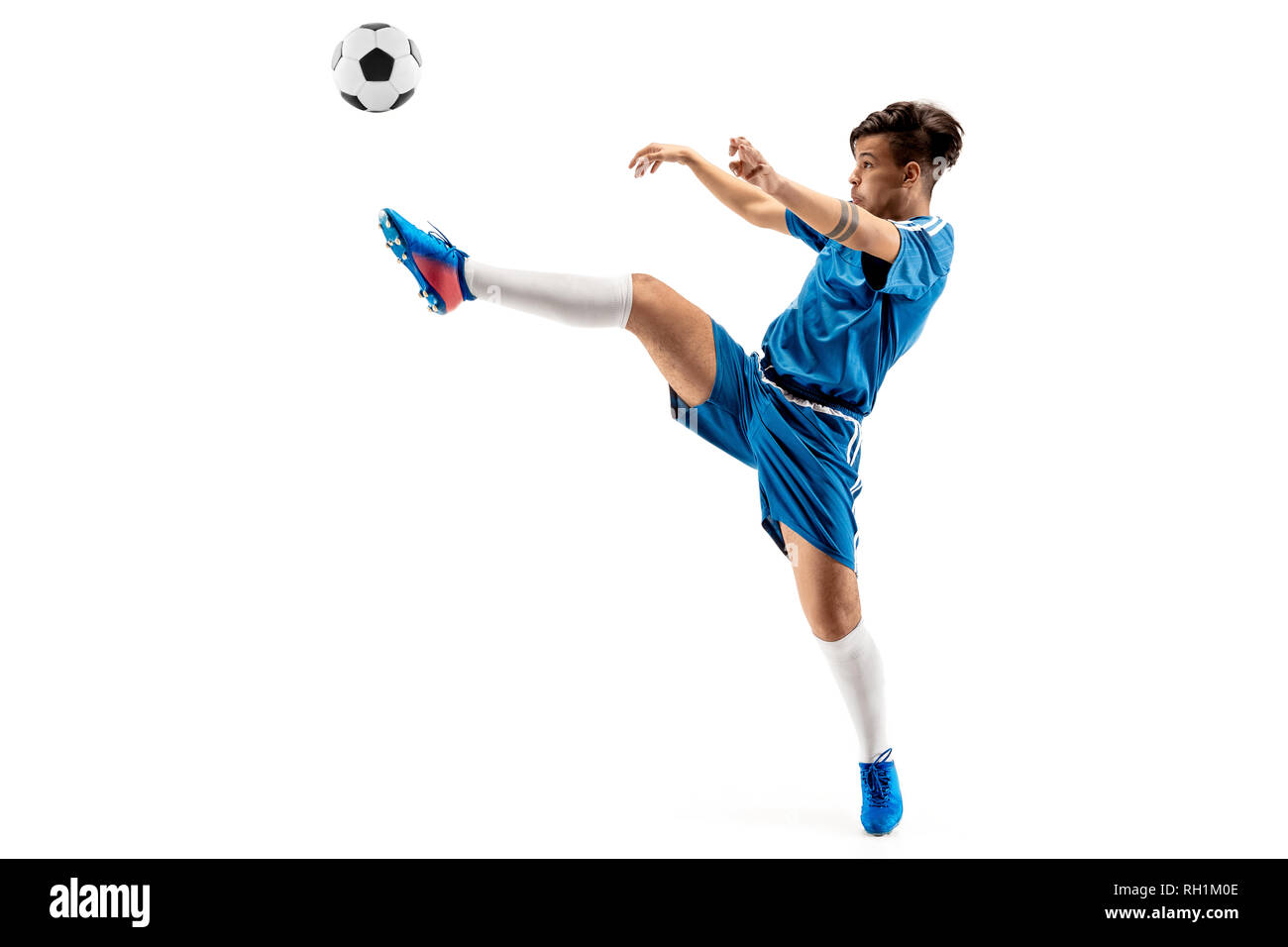 Young boy with soccer ball doing flying kick, isolated on white ...