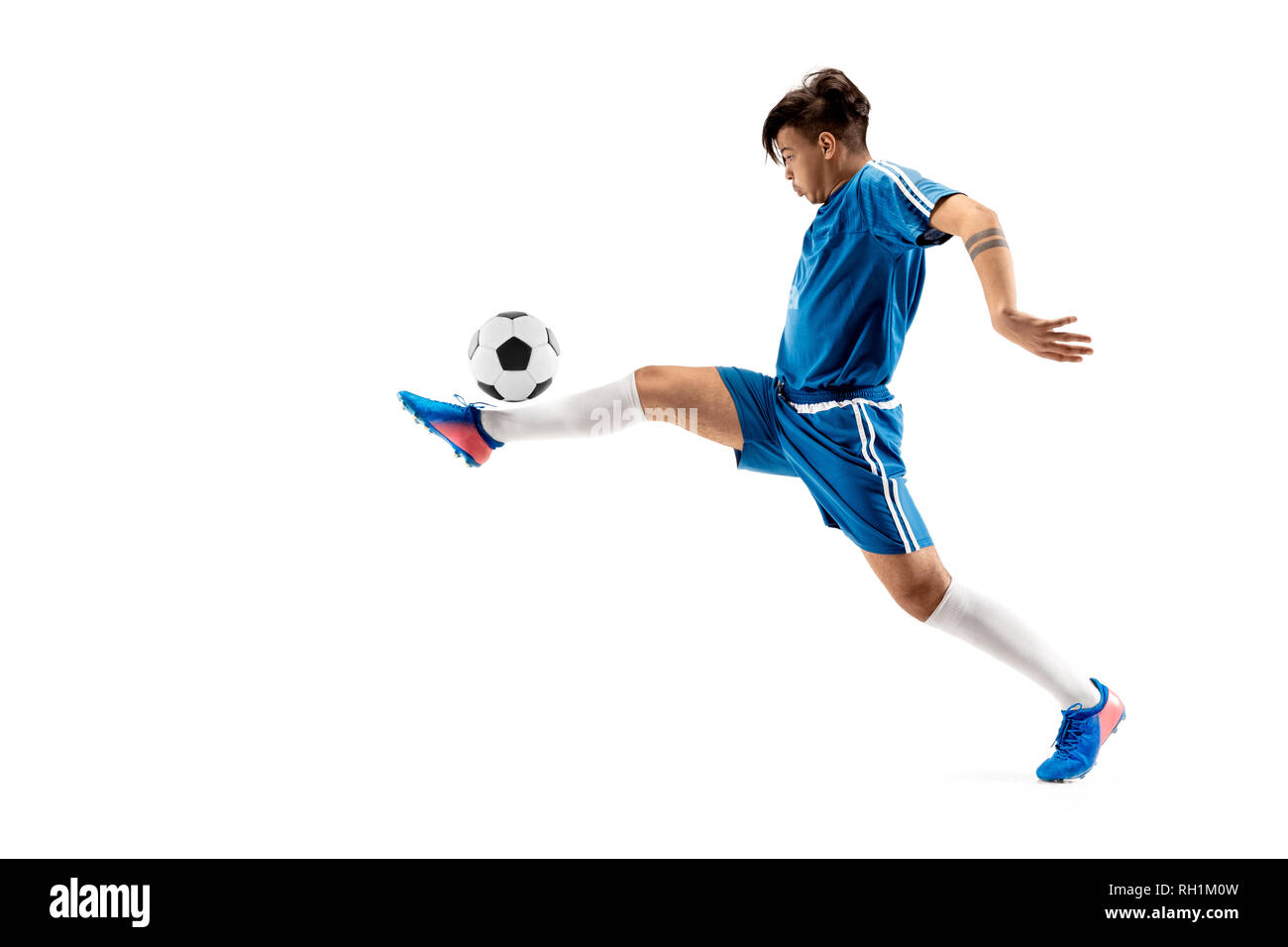 Young boy with soccer ball doing flying kick, isolated on white ...