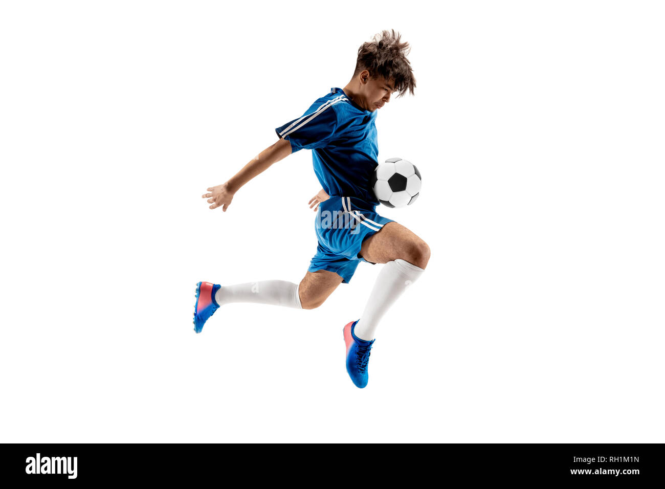 Young boy with soccer ball doing flying kick, isolated on white ...
