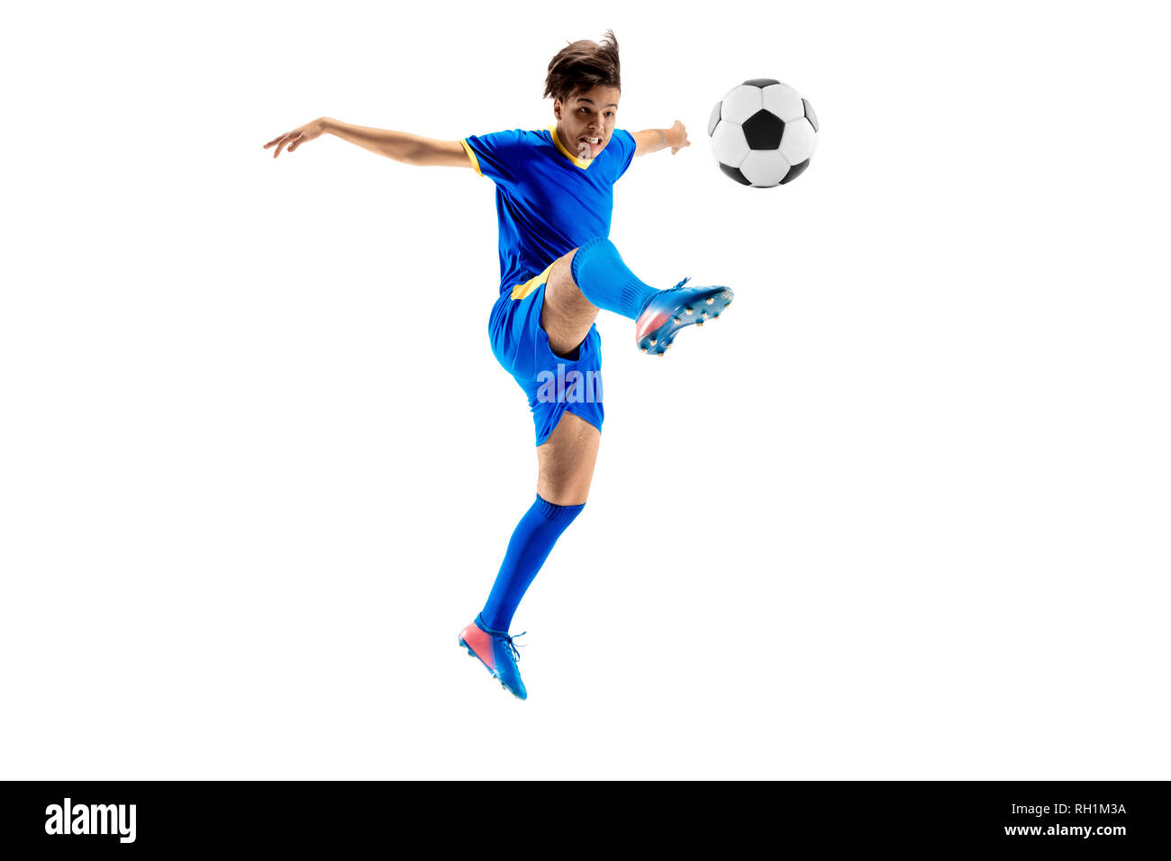 Young boy with soccer ball doing flying kick, isolated on white ...