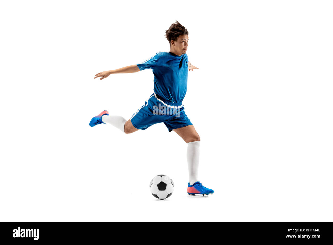 Young boy with soccer ball doing flying kick, isolated on white ...