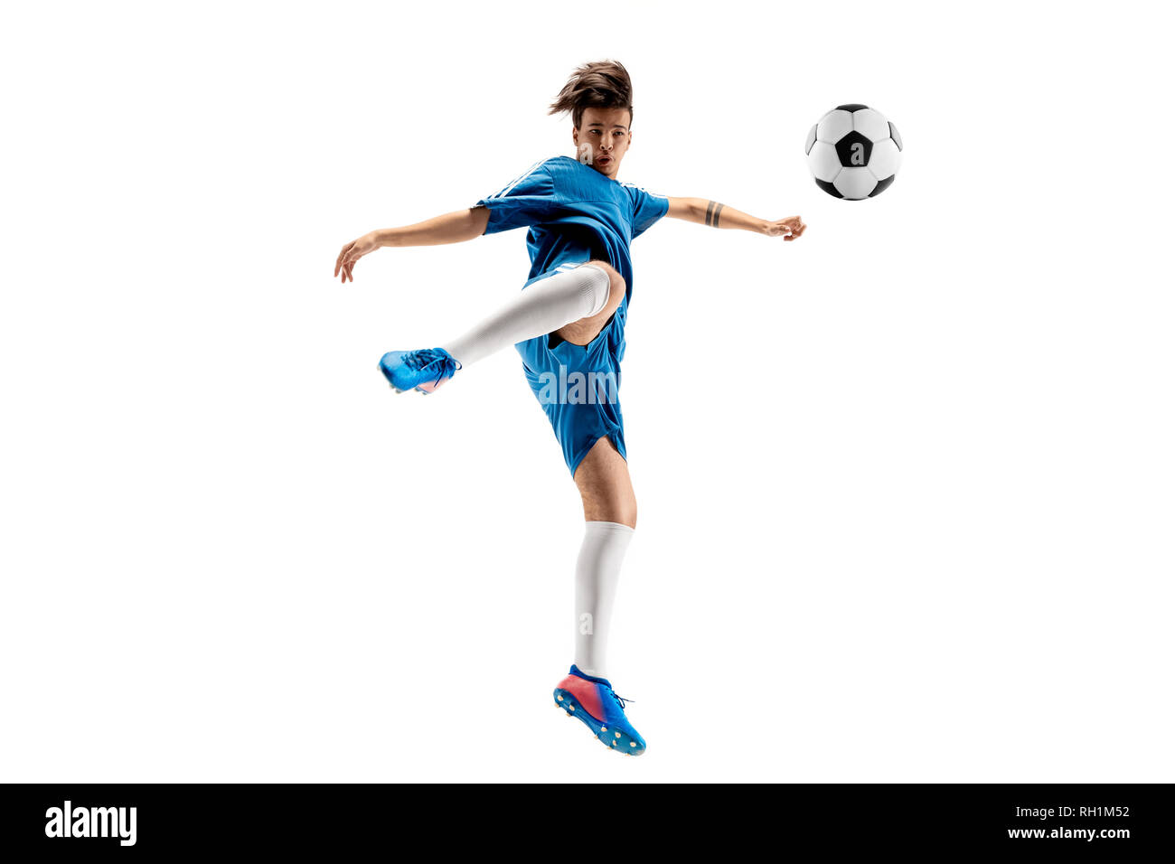 Young boy with soccer ball doing flying kick, isolated on white ...