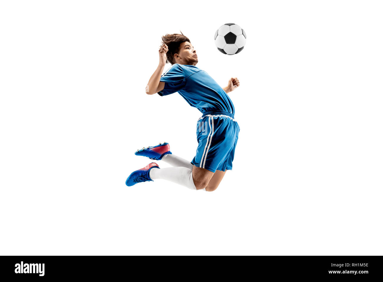 Young boy with soccer ball doing flying kick, isolated on white ...