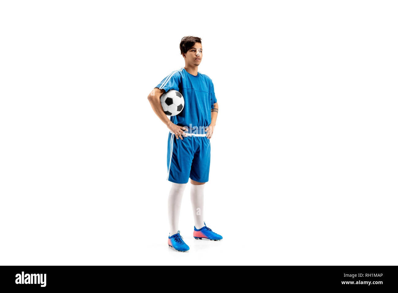 Young fit boy with soccer ball standing isolated on white as winner ...