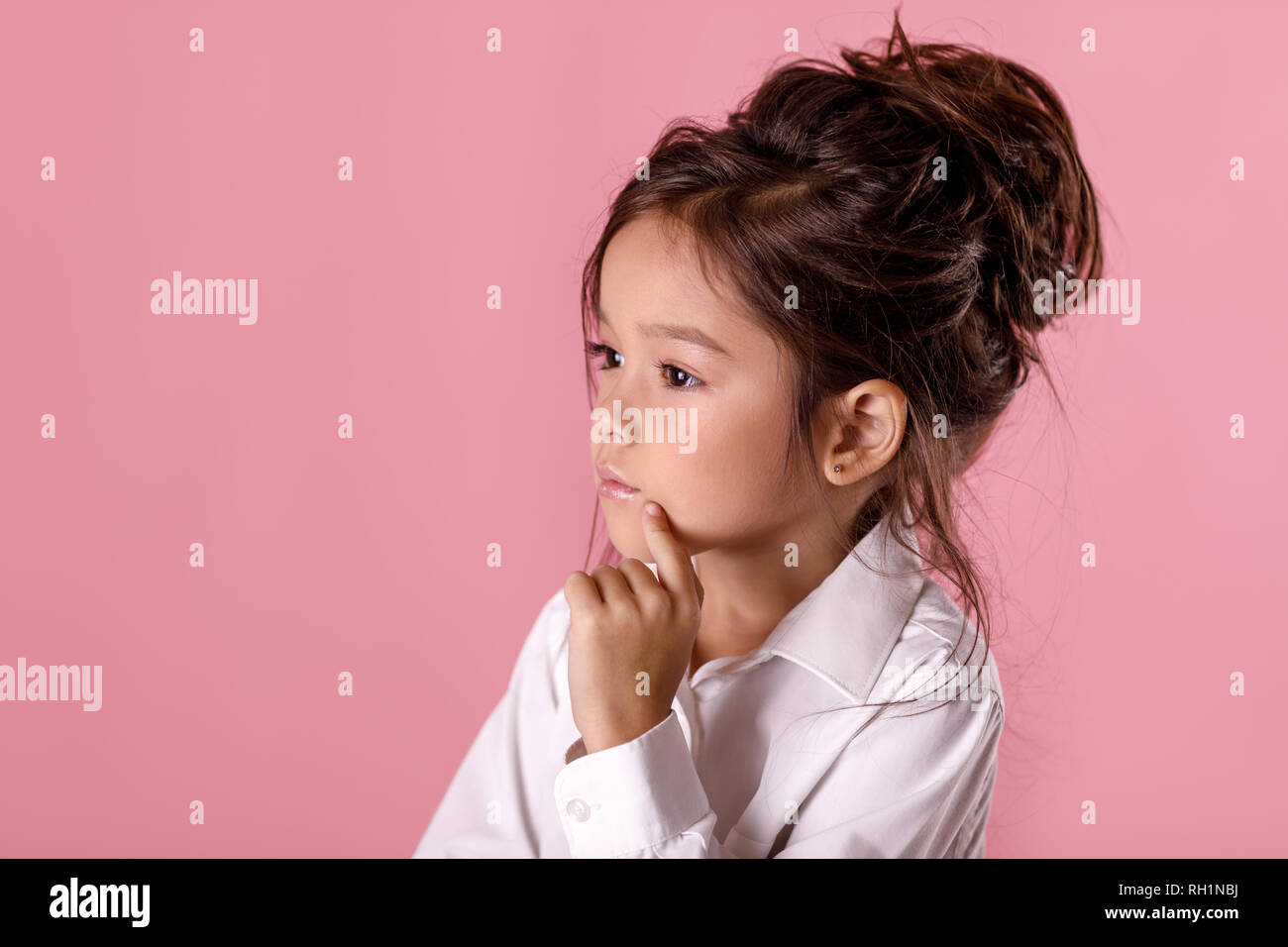 beautiful doubtful, thoughtful little girl in white shirt with ...