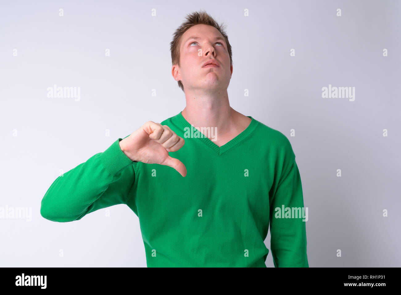 Portrait of stressed young man giving thumbs down Stock Photo - Alamy