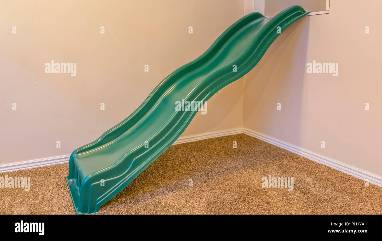 Interior of a room with a green slide for children Stock Photo - Alamy