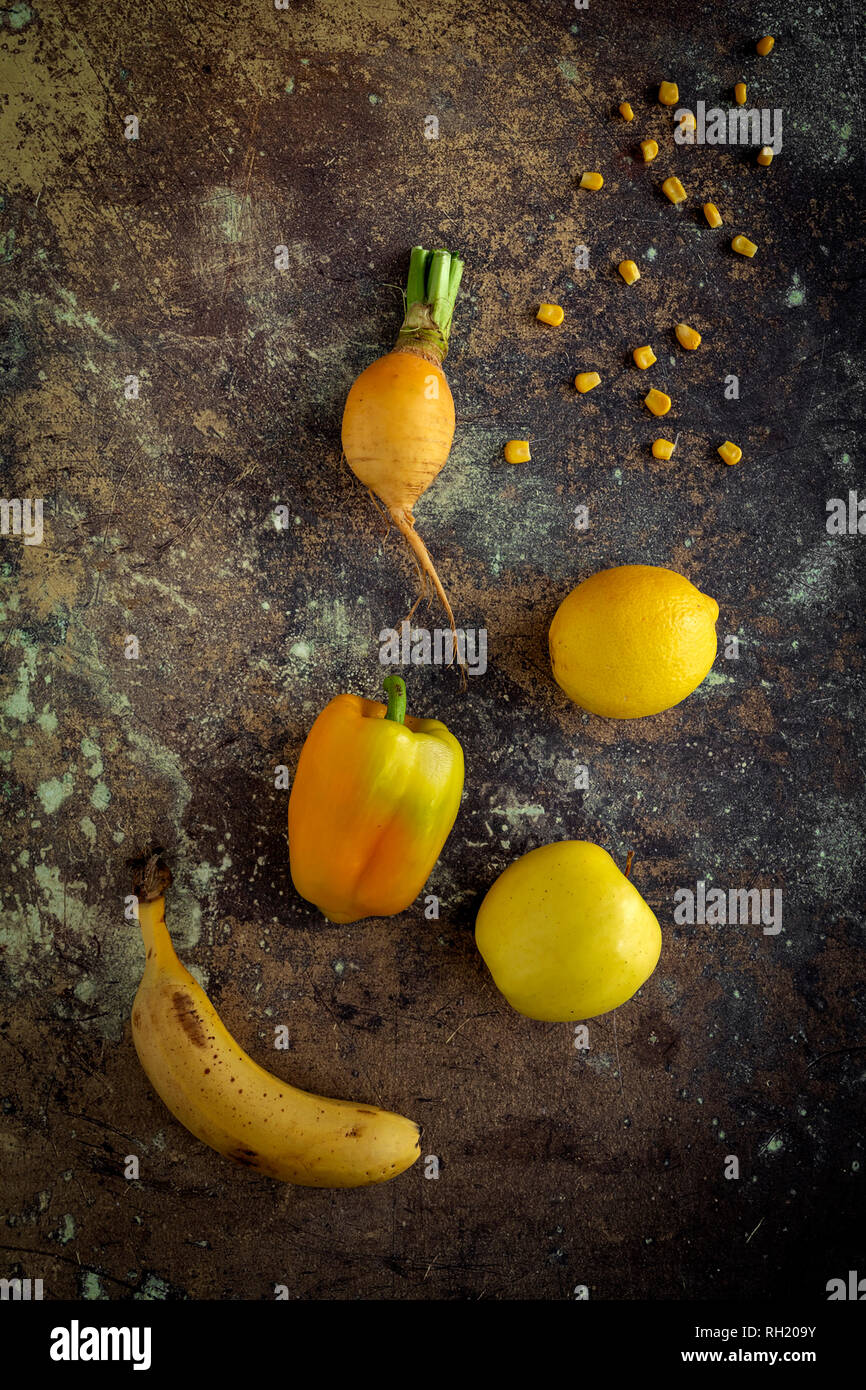 Mix of fruits and vegetables in yellow color on rusty background ...
