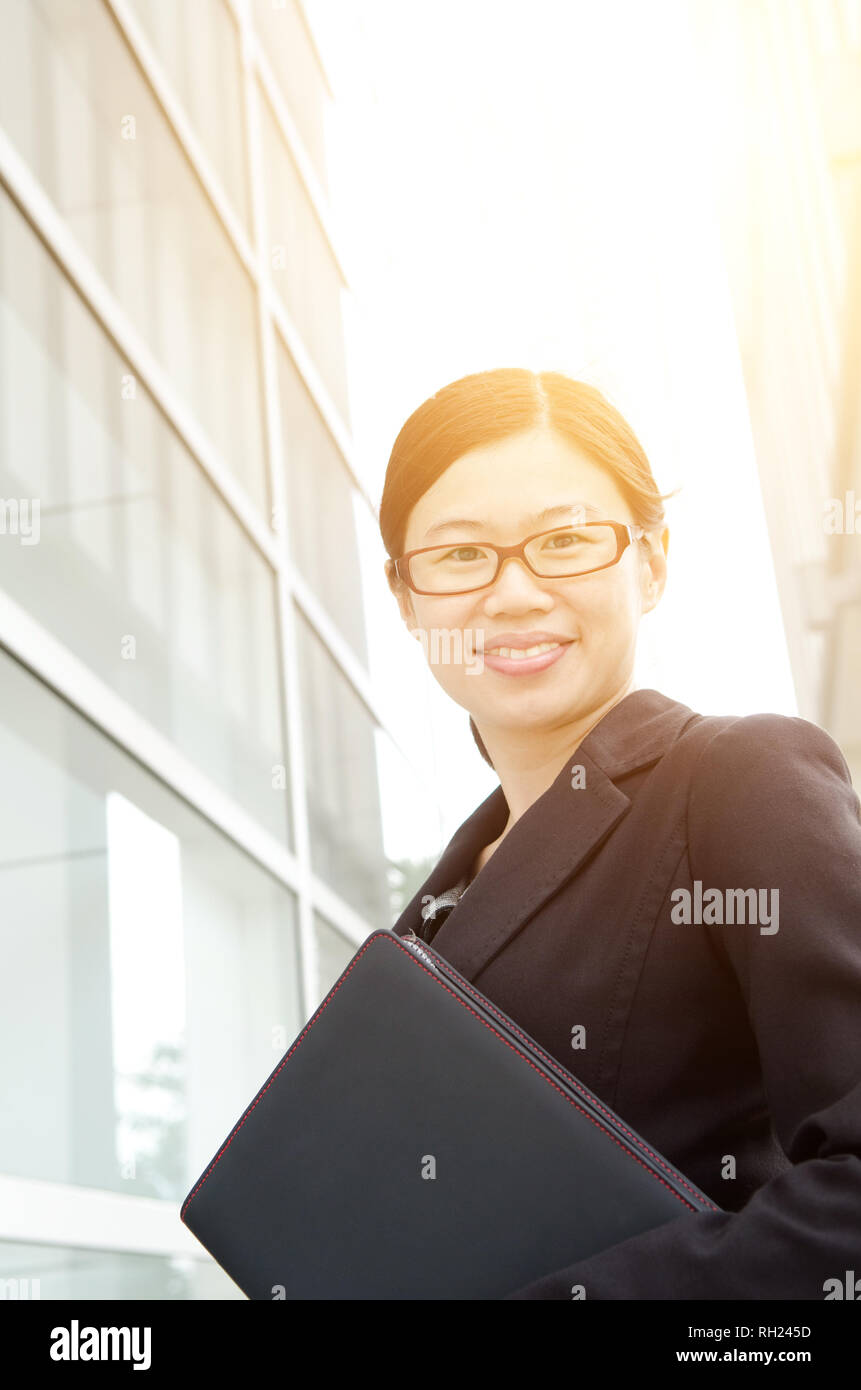 Asian executive smiles and standing outdoors Stock Photo - Alamy