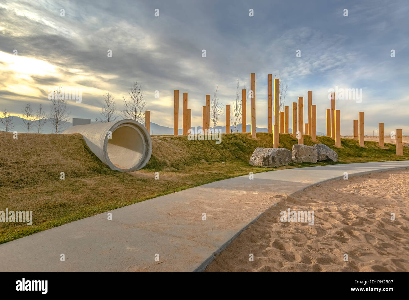 Pathway along slope with concrete pipe and poles Stock Photo - Alamy