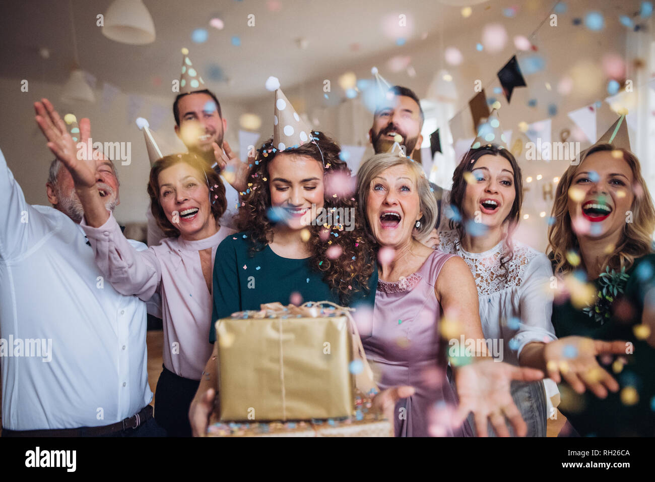 A portrait of multigeneration family with presents standing indoor on a ...