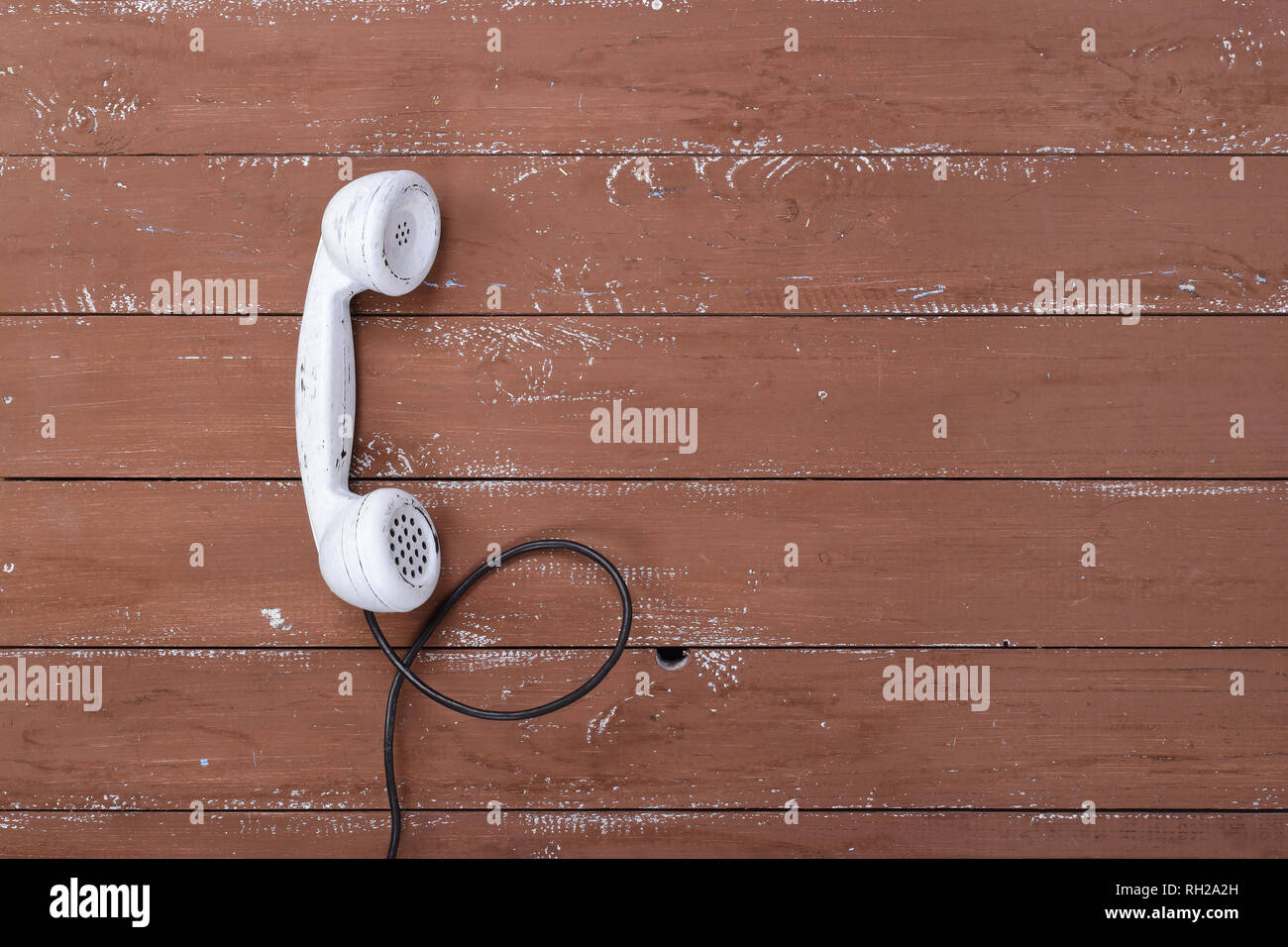 White handset vintage phone on a retro old brown wood textured plank ...