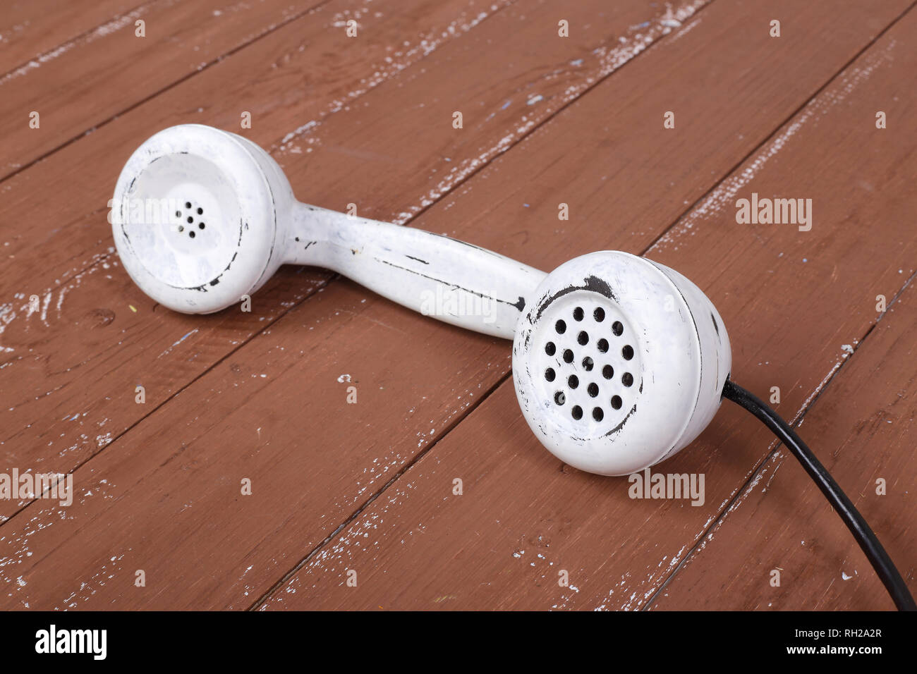 White handset vintage phone on a retro old brown wood textured plank ...