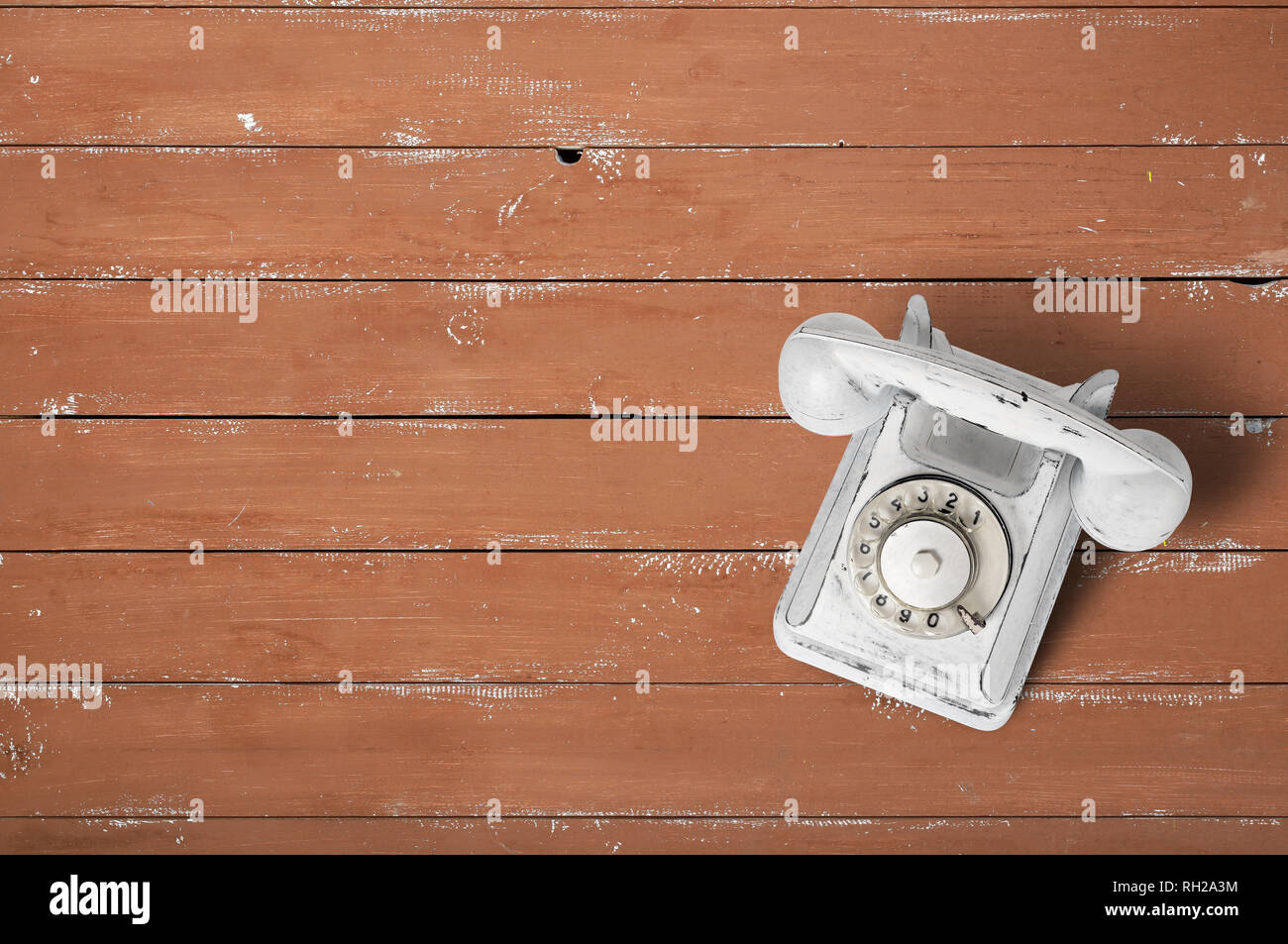 White vintage phone on a retro old brown wood textured plank background ...