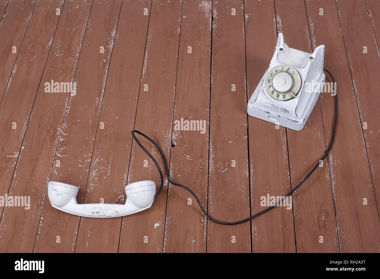 White vintage phone with the picked-up on a retro old brown wood ...