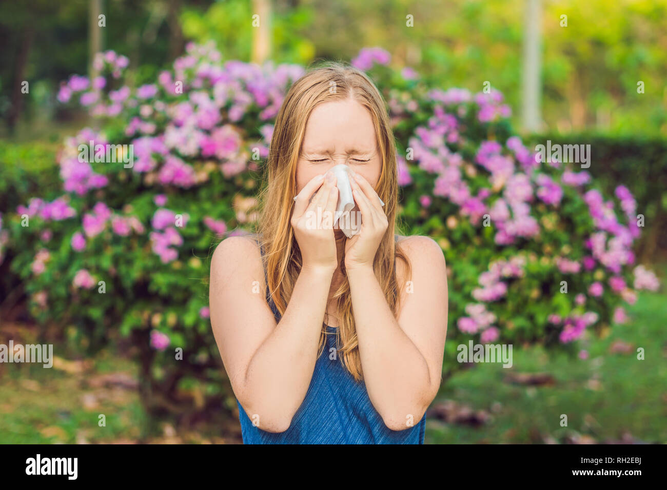 Pollen allergy concept. Young woman is going to sneeze. Flowering trees ...