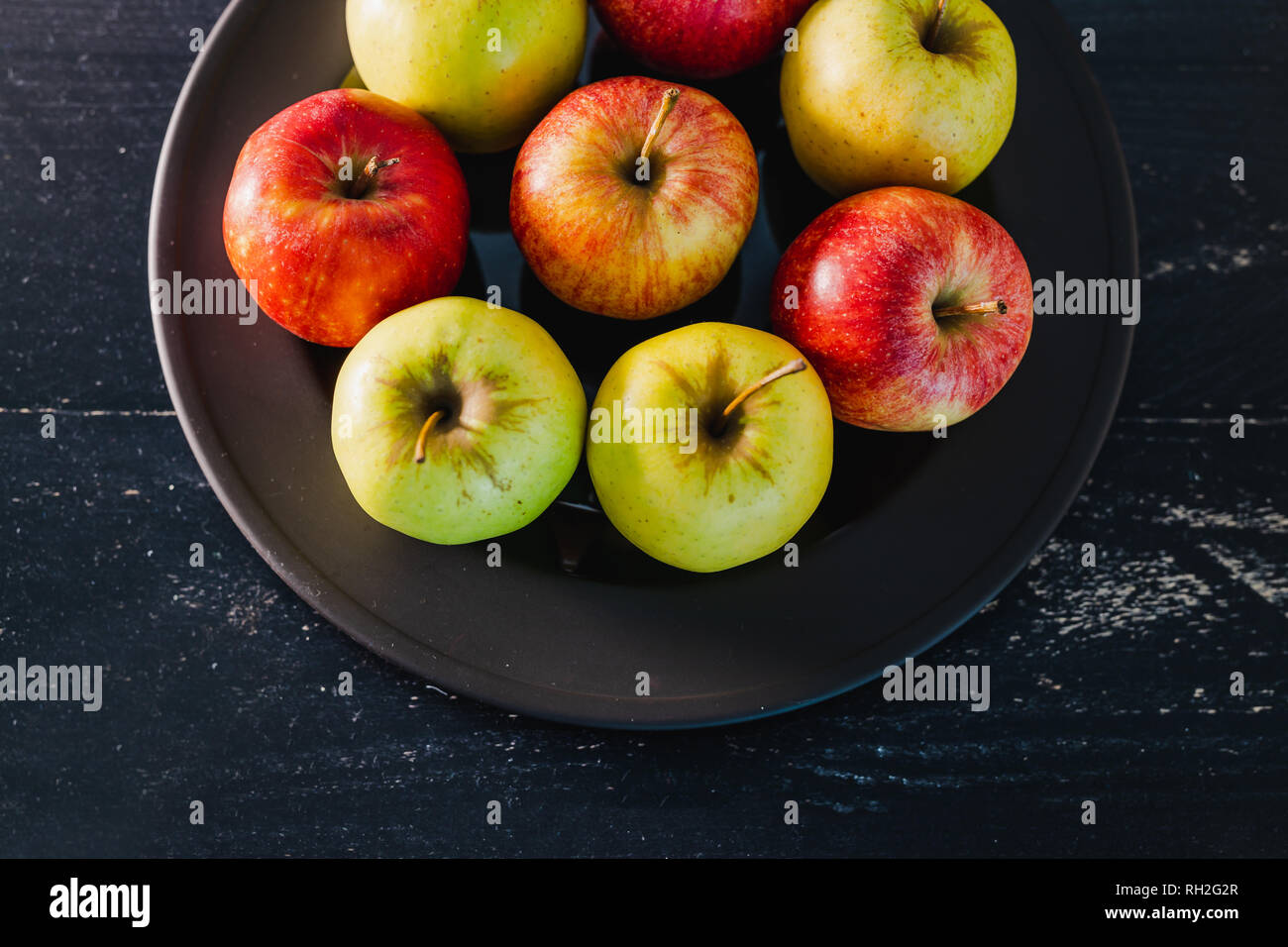 group of organic mixed colours red green and yellow apples on dark ...