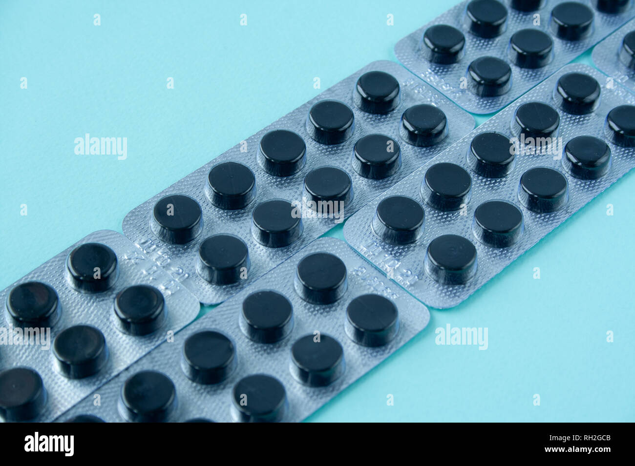 Activated carbon at blue background. packs of pills Stock Photo - Alamy