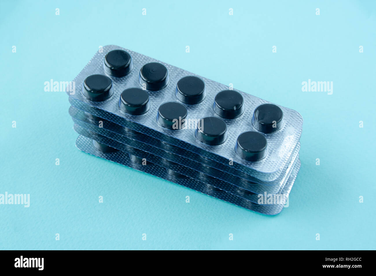 Activated carbon at blue background. packs of pills Stock Photo - Alamy