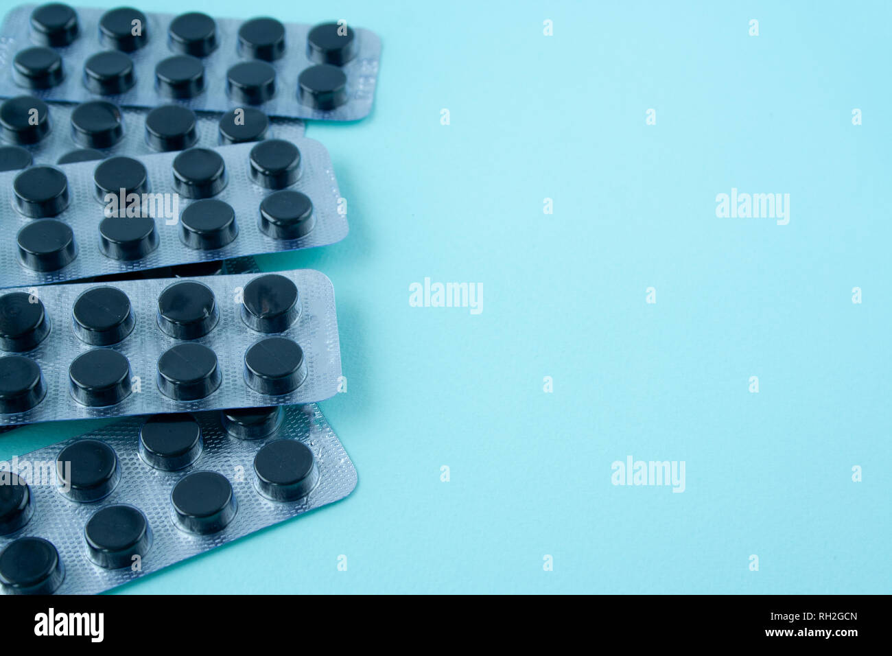 Activated carbon at blue background. packs of pills Stock Photo - Alamy