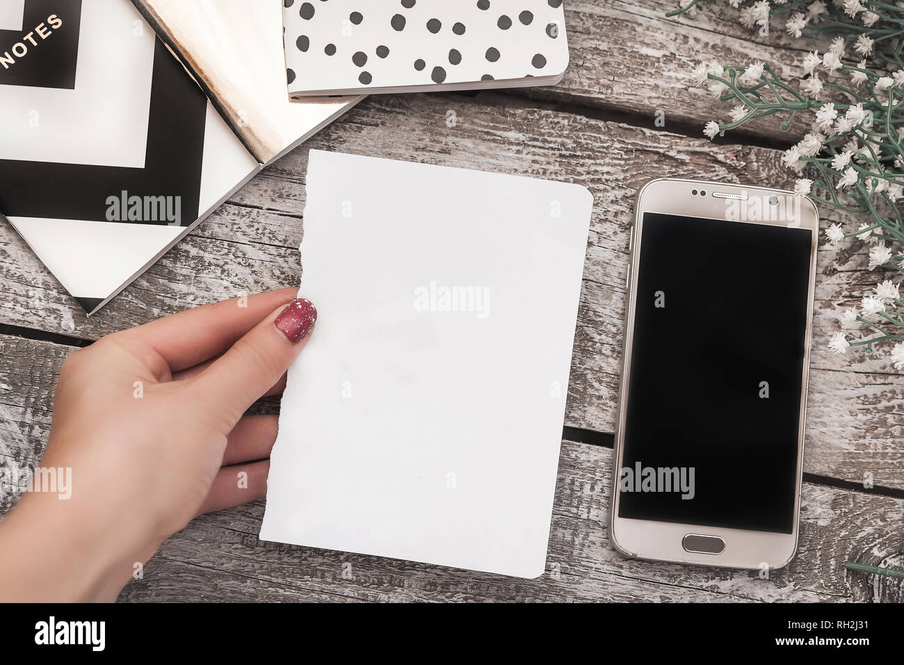 Woman hand holding paper note on wooden desk table top view with copy ...