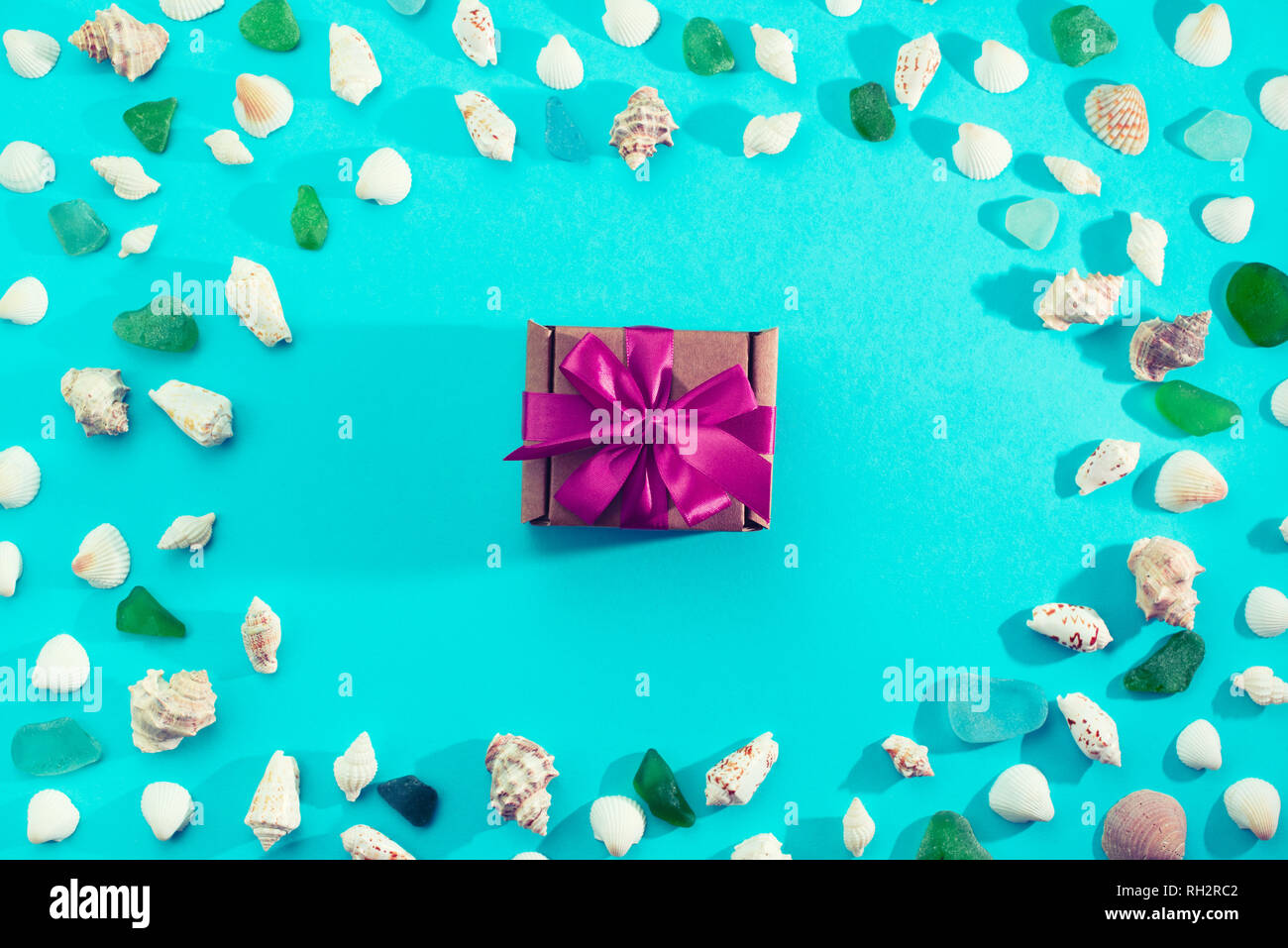 Different sea shells on blue background packing with gift. Top view ...