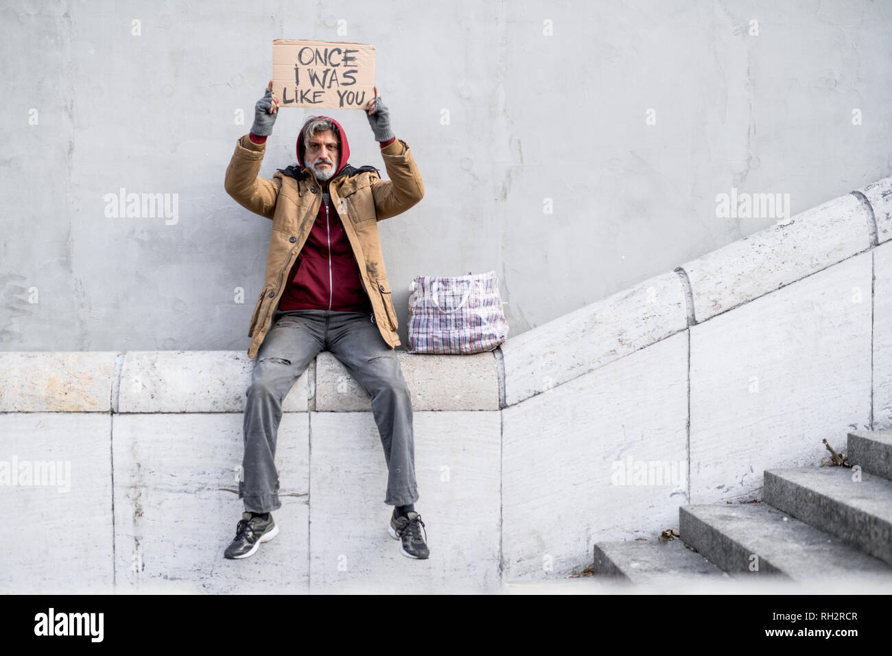 Homeless beggar man sitting outdoors in city holding will work for food ...