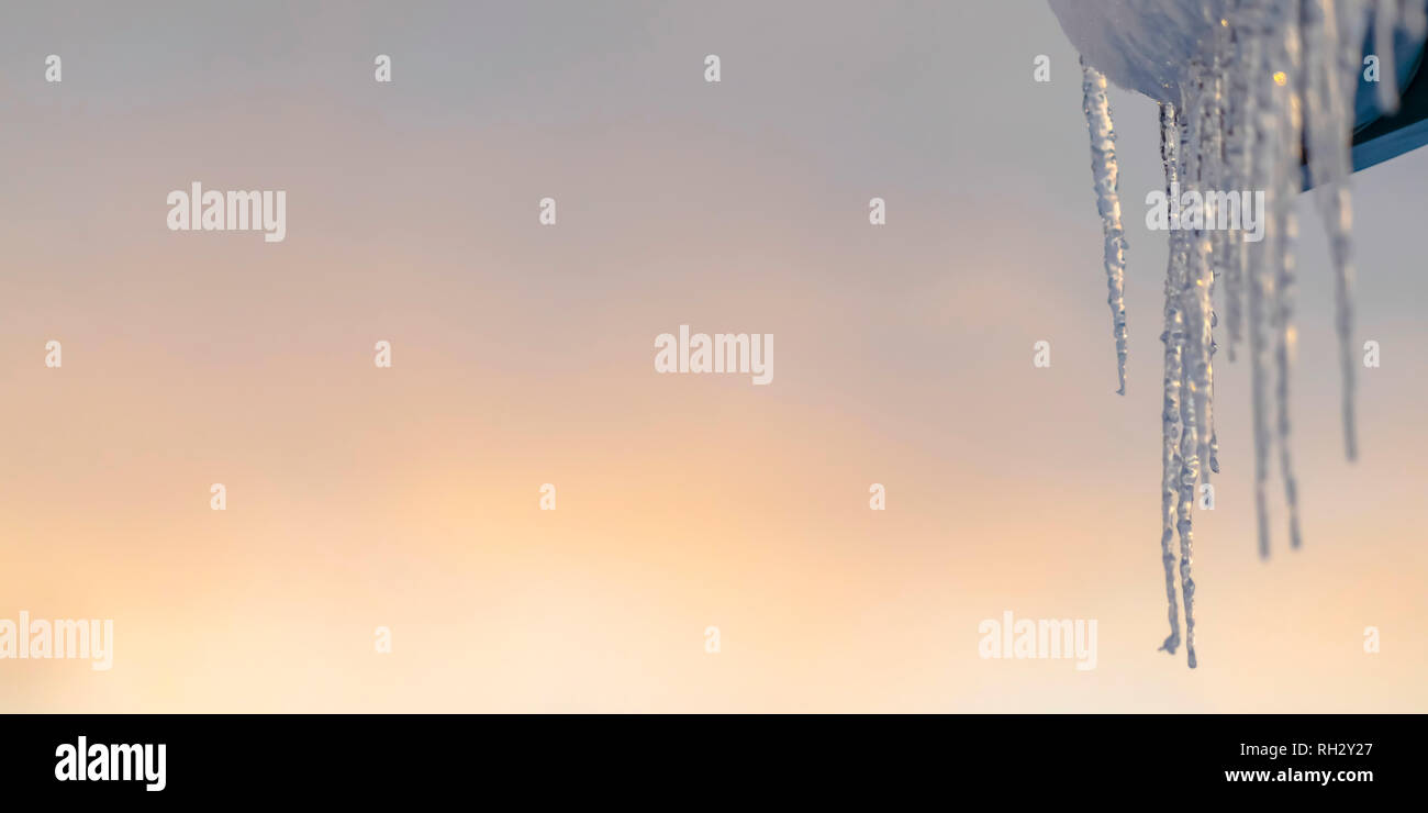 Sparkling icicles on a roof with sky background Stock Photo - Alamy