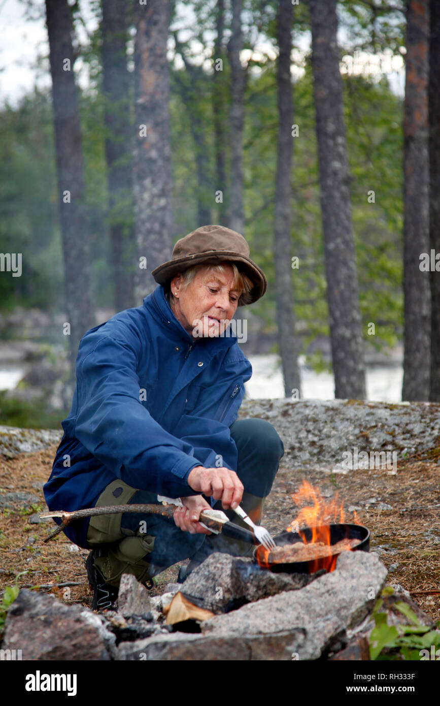 Woman cooking over fire Stock Photo - Alamy