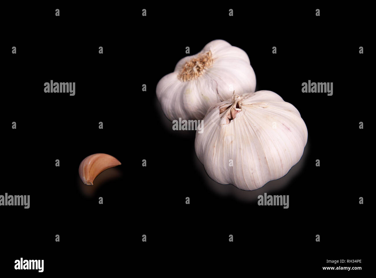Garlic head and cloves on blac background Stock Photo - Alamy