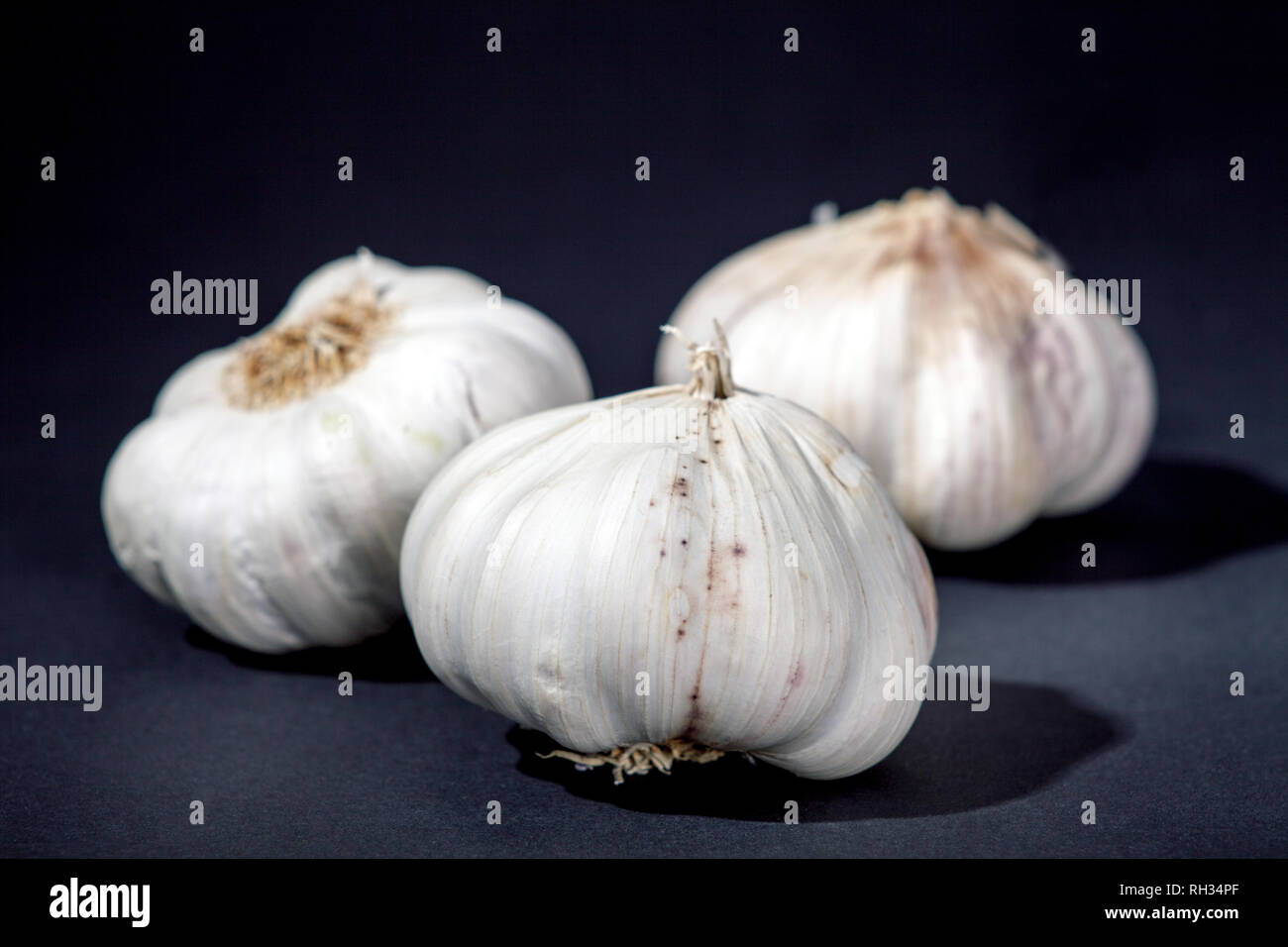 Garlic head and cloves on blac background Stock Photo - Alamy